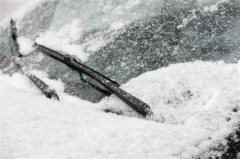 자동차 와이퍼 블레이드 자동차 창문에서 눈을 청소합니다 눈 조각이 두꺼운 층으로 차를 덮었다 작업 와이퍼와 깨끗한 앞 유리로 안전한 운전 바람막이 창에 대한 스톡 사진 및