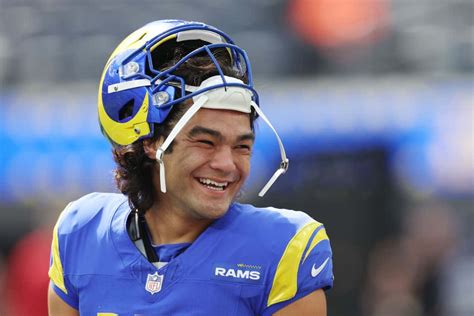 Download Smiling Football Playerin Blueand Yellow Uniform Wallpaper