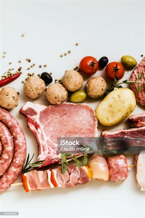다양 한 종류의 생고기 닭고기 허벅지 돼지고기와 쇠고기 버거 갈비와 케밥 칠면조 미트볼 감자 고추 올리브 및 검은 올리브와