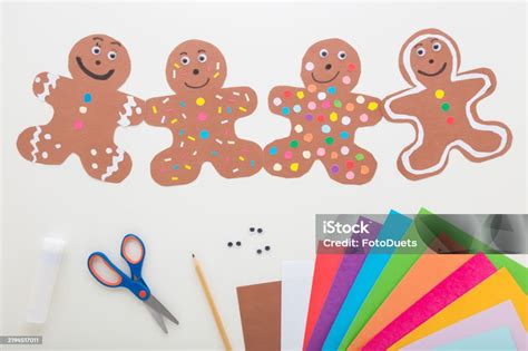 종이로 만든 갈색 진저 브레드 남자 모양 가위 접착제 스틱 연필 및 밝은 회색 테이블 배경에 다채로운 응용 프로그램 종이 장식 요소 만들기 근접 촬영 하향식 보기 0명에