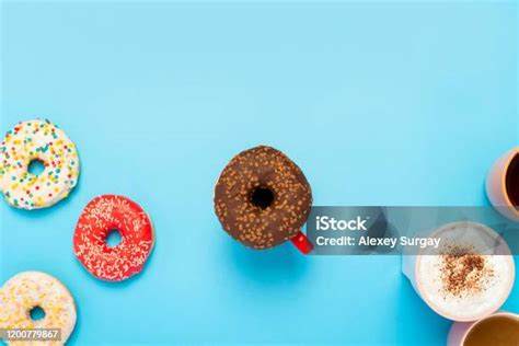 파란색 배경에 뜨거운 음료와 맛있는 도넛과 컵 과자 베이커리 패스트리 커피 숍의 개념 사각형 플랫 레이 상단 보기 0명에 대한