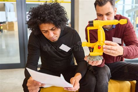 Engineers Developing Robotic Gripper Arm Design For Industrial