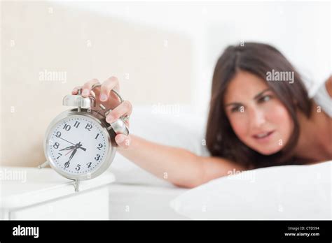 Brunette Turning Off Her Alarm Stock Photo Alamy