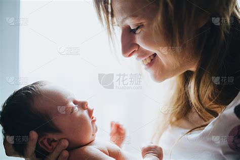 快乐的妈妈抱着她刚出生的小婴儿