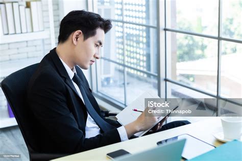 행복한 분위기 아시아 젊은 사업가의 쾌활한 아이디어는 사무실에서 나무 테이블 배경에 노트북과 컴퓨터에서 성공적인 사업 계획을 메모합니다 검사 보기에 대한 스톡 사진 및 기타