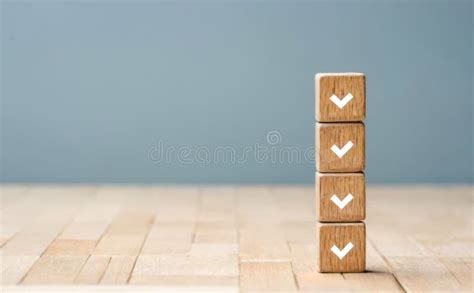 four wooden blocks stacked with check marks concept of task completion