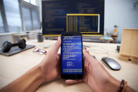 Male Hands Holding Smartphone With Code Lines While Programming Mobile App Stock Photo Image