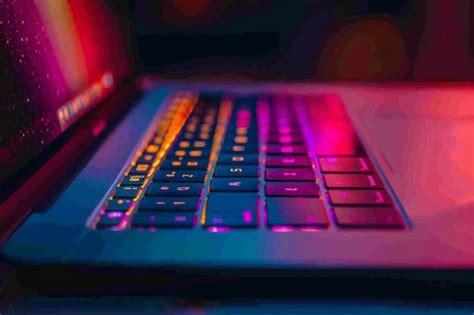 A Laptop Keyboard With Colorful Lights On It Shown In Closeup Premium Ai Generated Image