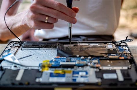 Man Repairing Laptop With Tools On Table Computer Maintenance Concept