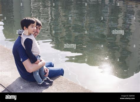 Father And Son Hanging Out At Riverbank Stock Photo Alamy