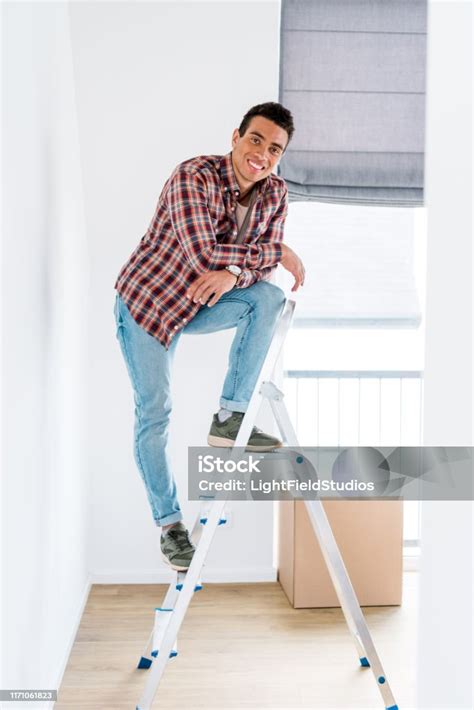 전체 길이보기 의 잘 생긴 아프리카 계 미국인 남자 서 에 단계 사다리 고 보고 에 카메라 계단 사다리에 대한 스톡 사진 및 기타 이미지 계단 사다리 데님 미소