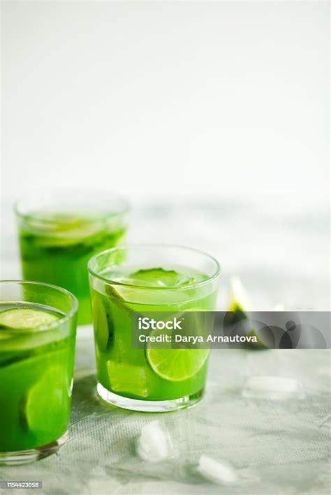집에서 만든 트 렌 디 한 아이스 말 차 또는 오이와 라임을 가진 레모네이드가 밝은 회색 배경에 있는 유리에 텍스트에 대 한