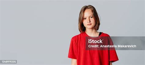 깔끔한 빛나는 얼굴 피부를 가진 똑똑한 잘 생긴 갈색 머리 십대 소녀는 캐주얼 빨간 티셔츠를 입고 카메라를 자신있게 바라보며 진지하고 집중적으로 보입니다 복사 공간 10