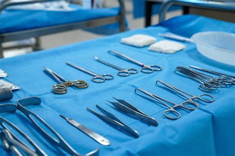 A Table Topped With Lots Of Surgical Tools On Top Of A Blue Cloth Covered Table