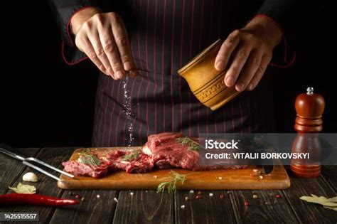요리사는 구워 먹거나 굽기 전에 신선한 쇠고기를 소금에 절입니다 레스토랑이나 호텔의 주방에서 일하는 환경 요리사에 대한 스톡