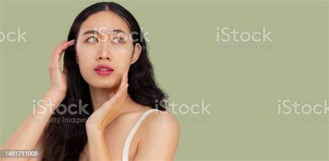 예쁜 아시아 여성의 긴 곱슬 헤어스타일 손이 얼굴 아름다움과 스파 개념을 만지고 녹색 파스텔 색 배경을 바라보고 있습니다 20 24세에 대한 스톡 사진 및 기타 이미지