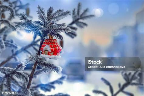 도시의 눈 덮인 겨울 거리에있는 크리스마스 트리에있는 장난감 빨간 집 눈부심 조명 흐림 텍스트를위한 공간 Charity