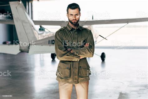 녹색 자 켓과 안경을 비행기 격납고에서 가까이 교차 무기와 포즈에 자신감이 유행 젊은이 남자에 대한 스톡 사진 및 기타 이미지 남자 몸짓 바람 Istock