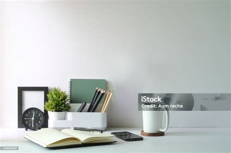 흰색 테이블에 알람 시계 커피 컵 책 연필 홀더 및 꽃 냄비가있는 홈 오피스 책상 공간을 복사합니다 0명에 대한 스톡 사진 및