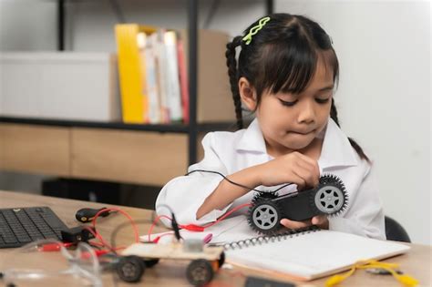 Premium Photo Asian Littlle Girl Constructing And Coding Robot At Stem Classfixing And Repair