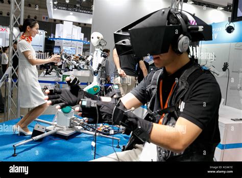 a booth assistant interacts with a master slave robot telesar v while a
