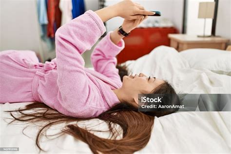 침실에서 침대에 누워 스마트폰을 사용하는 어린 중국 소녀 누워있기에 대한 스톡 사진 및 기타 이미지 누워있기 메시지 명랑한 Istock