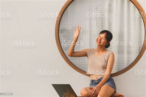 젊은 매력적인 아시아 프리랜서 여성은 여름 방학 동안 노트북 컴퓨터로 일하는 창문 집 앞 벤치에 앉아 있습니다 행복한 아시아 십대 학생 온라인 학습 20 24세에 대한 스톡