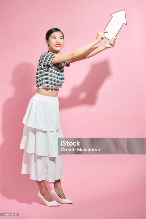 분홍색 배경에 고립 된 빈 연설 화살표 포인터를 들고 미소 예쁜 빨간 머리 곱슬 여자의 초상화 가리키기에 대한 스톡 사진 및 기타 이미지 Istock