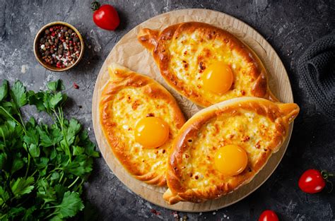 치즈로 속을 채우고 달걀 노른자를 얹은 Ajarian Khachapuri 어두운 배경에 전통적인 조지아 Khachapuri 계란 노른자에 대한 스톡 사진 및 기타 이미지