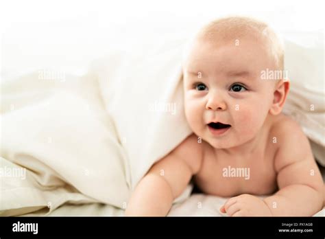 Happy Cute Baby Lying On White Sheet Stock Photo Alamy