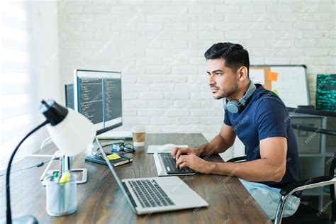 Premium Photo Handsome Young Male Programmer Coding While Typing On Computer Keyboard At Desk