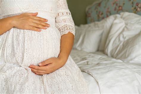 임신 한 여자는 그녀의 아이를 돌보는 동안 집에서 행복을 느낀다 임신 한 배에 아기를 들고 젊은 기대 어머니 출산 전 관리 및 여성 임신 개념 개념에 대한 스톡 사진 및