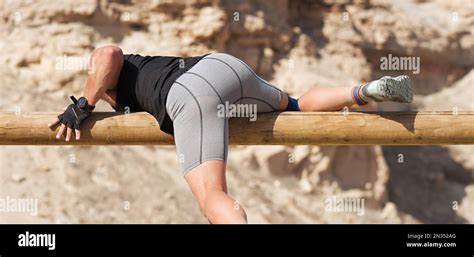 participant in an obstacle course running and climbing a wall jump