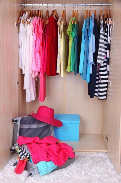 Premium Photo Female Clothes In Wardrobe And Suitcase In Room