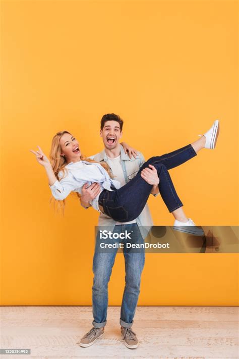 노란 배경위에 고립된 승리의 표지판을 보여주는 아름다운 여자를 품에 안고 있는 잘생긴 남자의 전체 길이 사진 20 29세에 대한 스톡 사진 및 기타 이미지 Istock