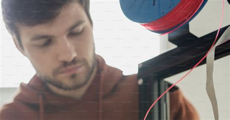 스크루 드라이버를 가진 젊은 기술자는 프린트 헤드를 수리하거나 사무실에서 3d 프린터 패널 중 하나를 고정합니다 사진