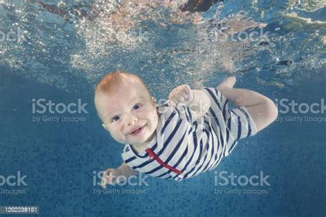 줄무늬 양복을 입은 어린 소년은 수영장에서 수중 수영을 배운다 건강한 가족 라이프 스타일과 어린이 수상 스포츠 활동 아동 발달질병 예방 6 11 개월에 대한 스톡 사진 및