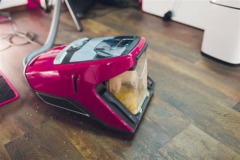 양탄자를 진공 청소기로 청소하는 동안 사용되는 현대 진공 청소기의 어두운 머리 청소 서비스 개념입니다 진공 청소기로 카펫을 처리합니다 가사 집안일에 대한 스톡 사진 및 기타