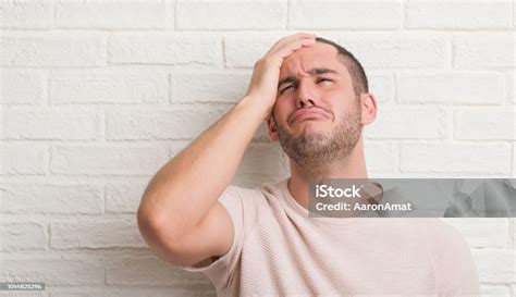 젊은 백인 남자 머리 수치심과 깜짝 얼굴로 충격된에 손으로 압박 흰색 벽돌 벽을 통해 서 분노 하 고 좌절 두려워 하 고 실수에 대 한 화가 감정에 대한 스톡 사진 및 기타