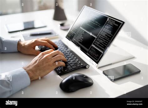 Computer Programmer Writing Program Code On Computer In Office Stock