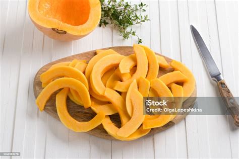 얇게 썬 호박 씨앗이 없는 반 껍질을 벗긴 호박 흰색 배경에 백리향과 부엌 칼이 있는 나무 보드 평면도 맛있는 수제 음식