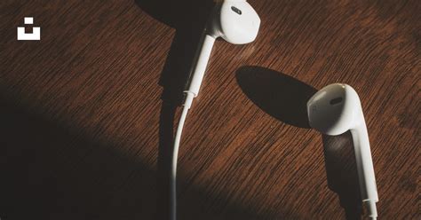 갈색 나무 테이블에 흰색 이어 버드 사진 Unsplash의 무료 갈색 이미지