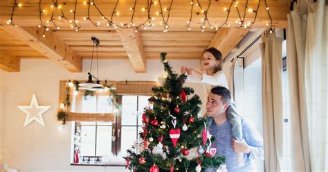 어린 딸에게 함께 크리스마스 트리를 장식하는 피기백을 주는 젊은 아버지 사진 Unsplash의 나무 이미지