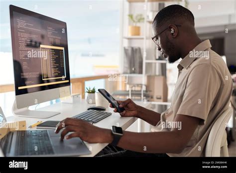 Software Developer Checking Messages And Notifications On Smartphone