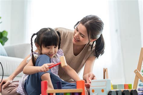 아시아의 아름다운 사랑하는 엄마는 집에서 딸과 함께 교육 게임을합니다 매력적인 여성 부모는 어린 소녀 아이와 함께 무료 여가 시간을 보내고 아이의 장난감으로 기술을 배우고