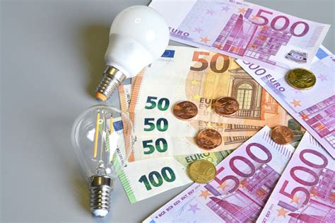 전기 플러그 유로 머니 지폐 및 회색 배경 위에 전구가있는 센트 전기 비용의 증가를위한 개념 비싼 에너지 요금과 전기 가격의