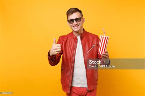 3d 안경에서 보 그 젊은 남자의 초상화 빨간 가죽 자 켓 티셔츠 보고 영화 필름 소 다 또는 콜라 밝은 노란색 배경에 고립의 컵을 들고 사람들이 진심으 감정 라이프 스타일