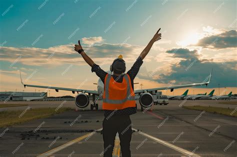 caucasian aircraft marshalling giving signals to the airplane pilot
