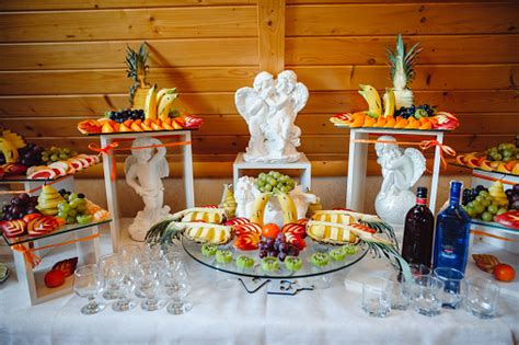 달콤한 축제 테이블을 위한 맛있는 간식입니다 나무 배경에 천사 인형으로 장식 과일 축제 달콤한 테이블 결혼식 뷔페 필름 곡물 과일에 대한 스톡 사진 및 기타 이미지 Istock