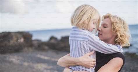 젊은 아름 다운 금발 동유럽 어머니 여자는 사랑과 공생의 감정과 느낌으로 그를 포옹하면서 아들에 키스합니다 멋진 가족을위한 삶과 라이프 스타일을 즐기십시오 야외 활동